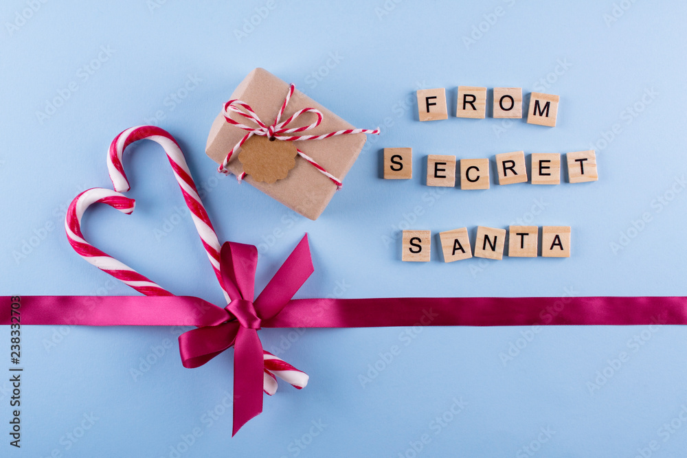Present from secret Santa. Wrapped gift box with notes, candy cane and ...