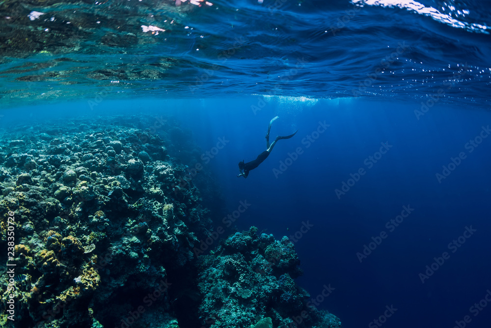 Free diver man dive in ocean, underwater view with rocks and corals ...