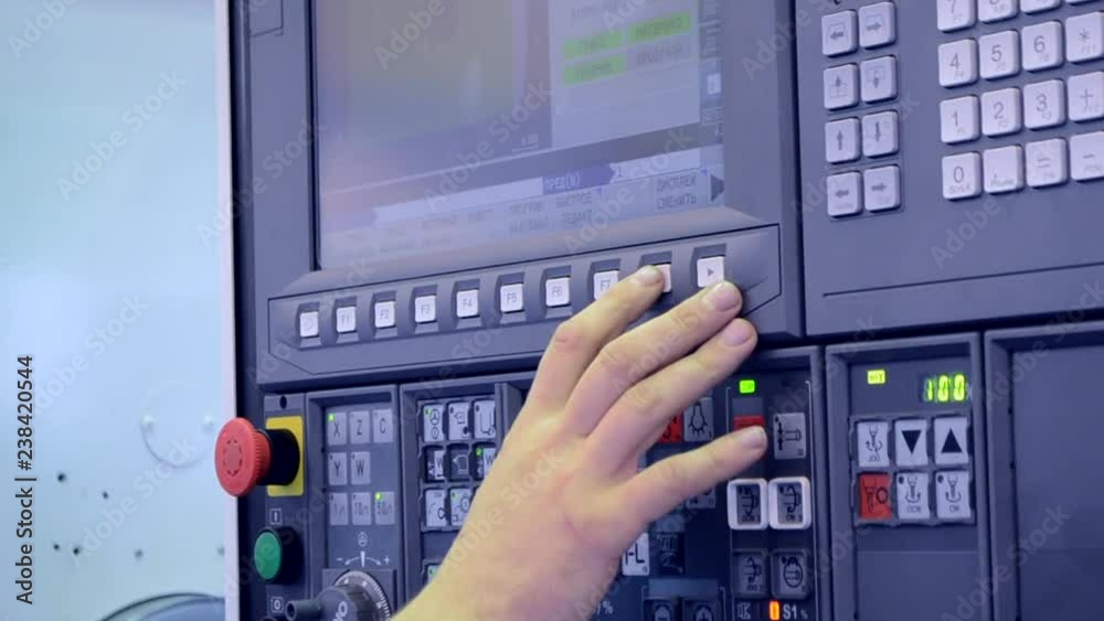 Man working on the control panel works with an industrial machine at ...