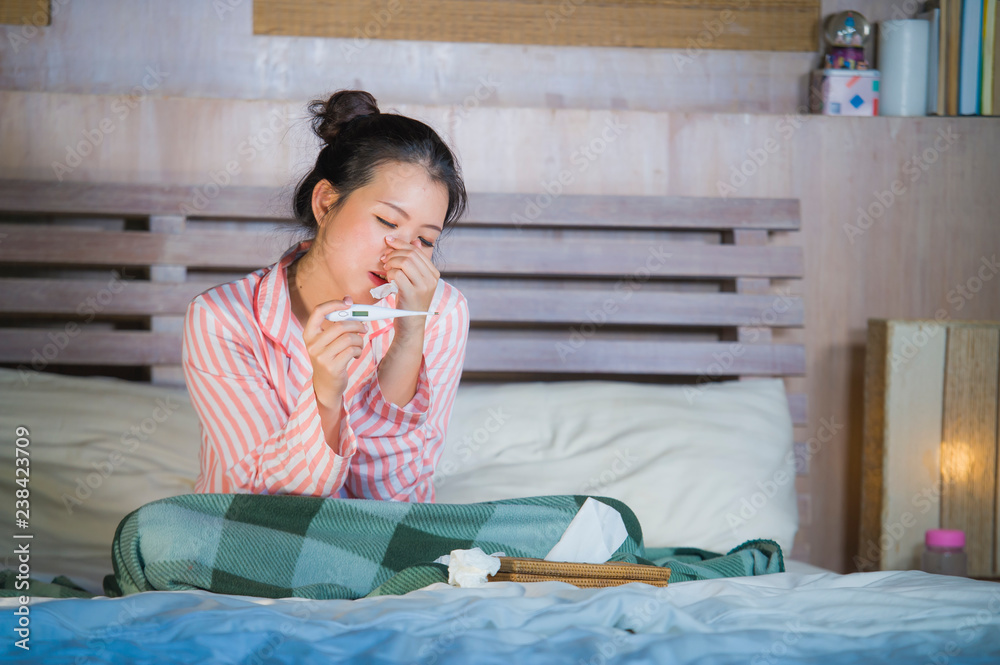 sweet Asian Japanese woman in pajamas sick at home bedroom suffering ...