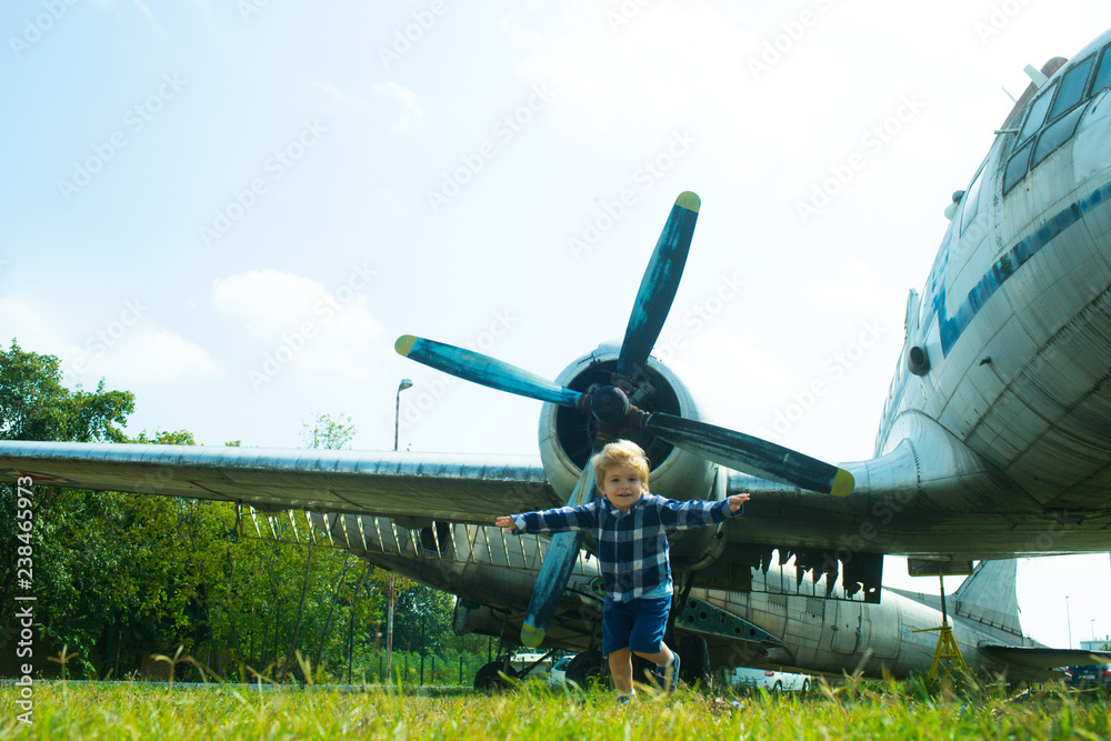 Plane and child. Boy is running from big plane on green glade. Fun and ...