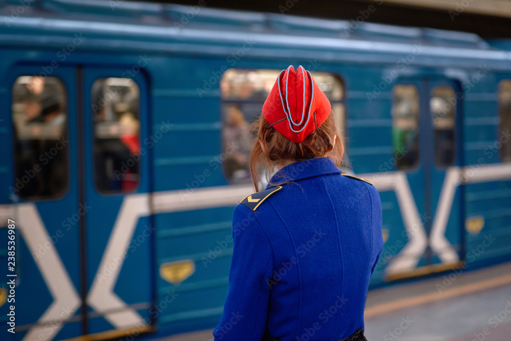 Metro worker in uniform and red cap is on duty at the station. Subway ...
