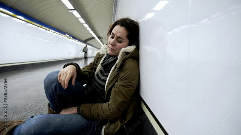 Hopeless and exhausted woman suffering depression and anxiety in subway ...