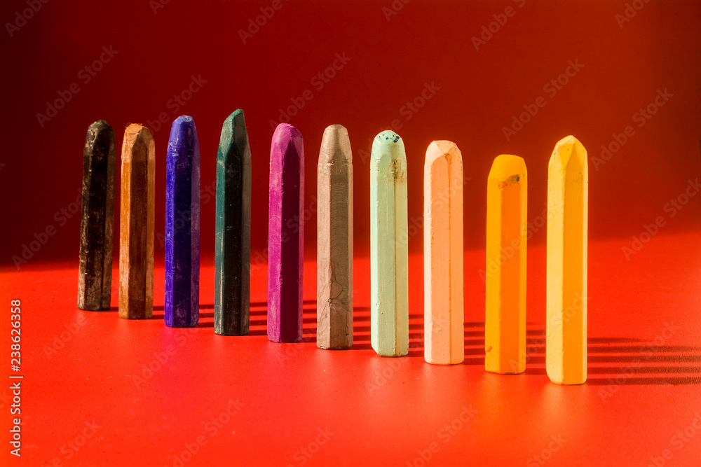 colorful crayons are set up in a line and cause shadows to line up ...