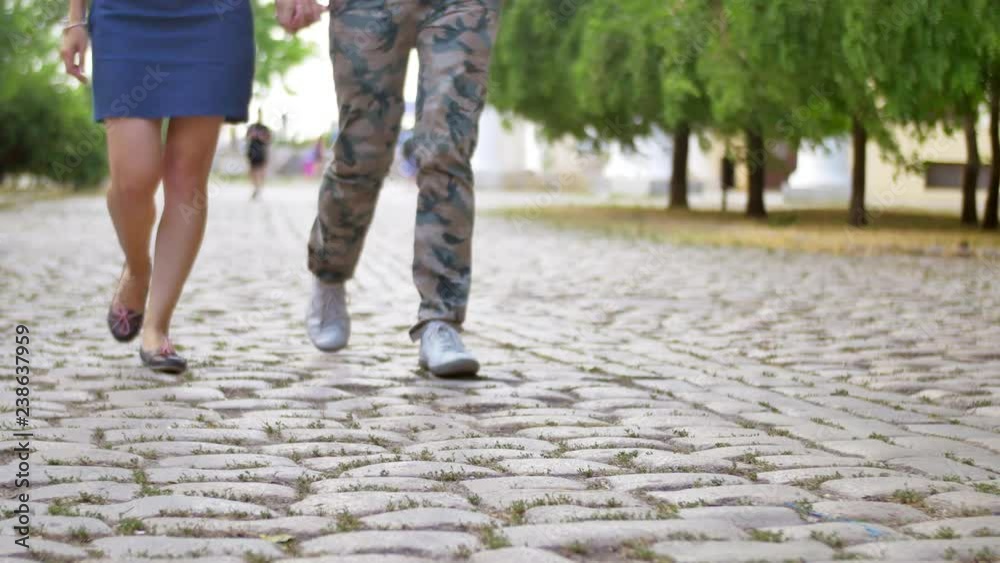 Romantic couple legs walking city street, holding hands together. Young ...