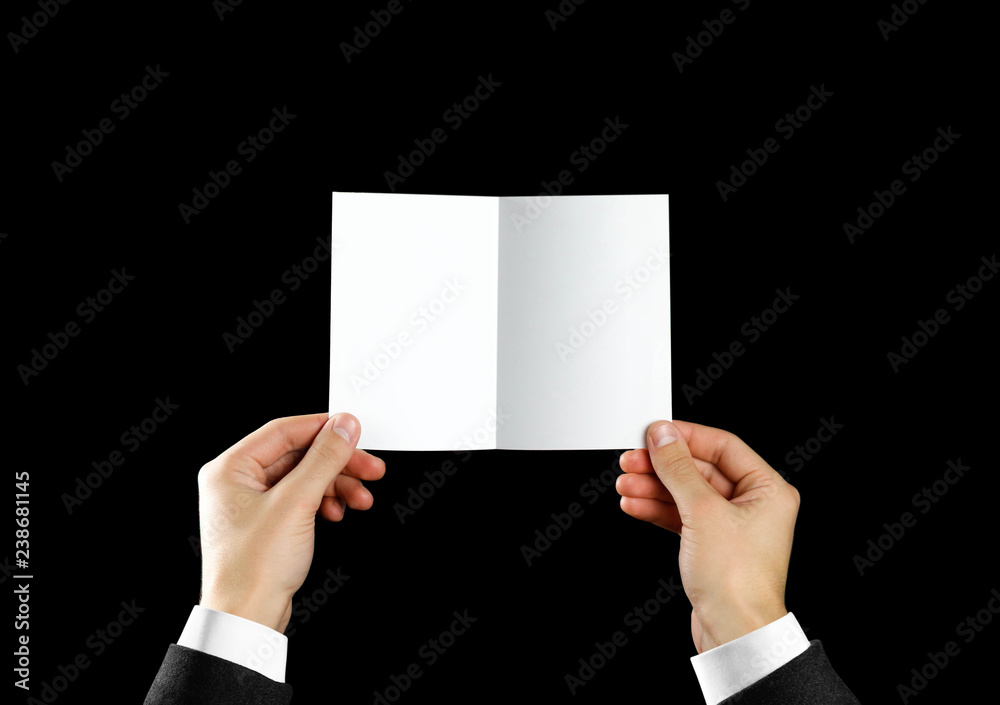 Hand holding blank brochure booklet in the hand. Isolated on black ...