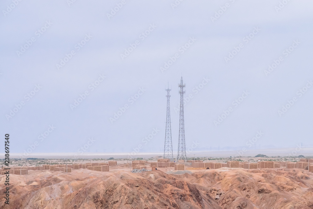 Telephone towers and brick houses in the middle of gobi desert near the ...