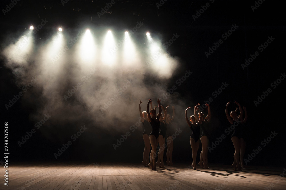 Ballet class on the stage of the theater with light and smoke. Children ...