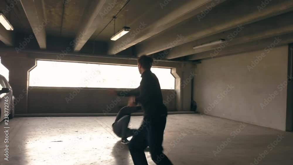 Fight in a parking deck. Two men in a physical confrontation throw ...