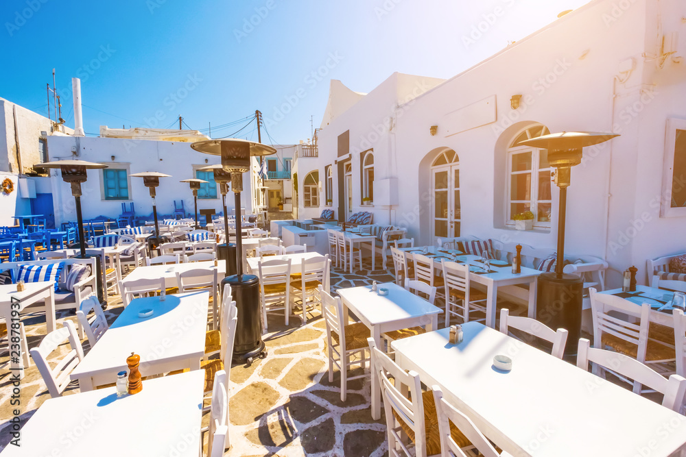 Tables and chairs outdoors in traditional Greek cafe. Typical Greek ...