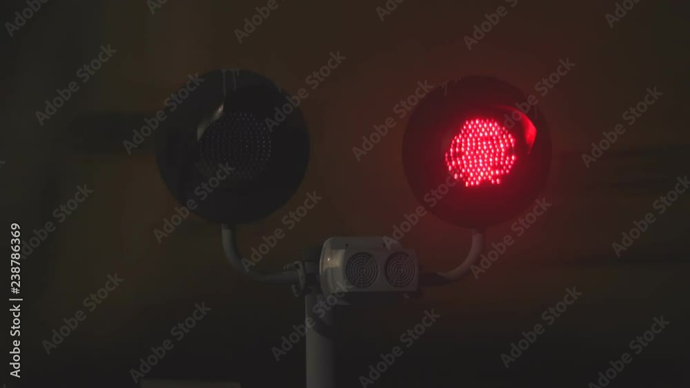 Flashing red traffic light at a railway crossing at night on the ...