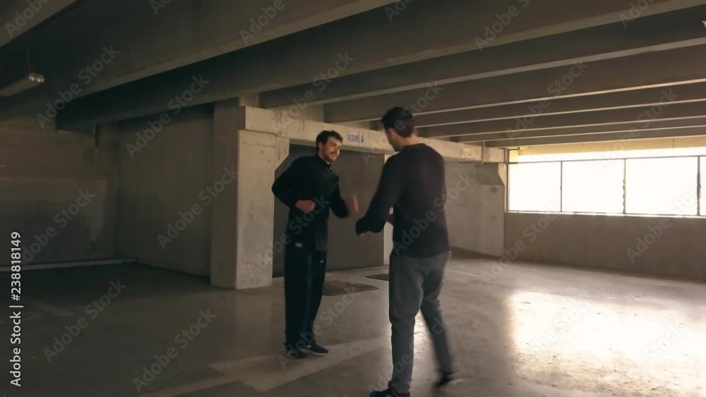 Stockvideo Wide view of actors practicing a fight scene in a parking ...