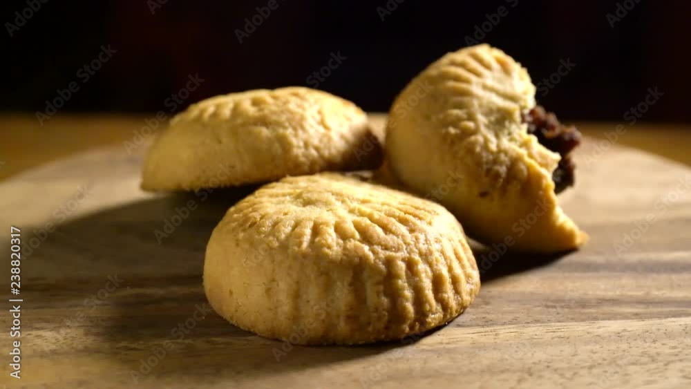 Three maamoul, arabic cookies with one broken open to see the date ...