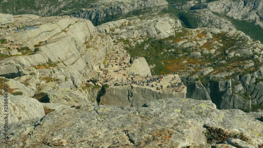 Panning high angle shot of Pulpit rock, people dangerously close to the ...