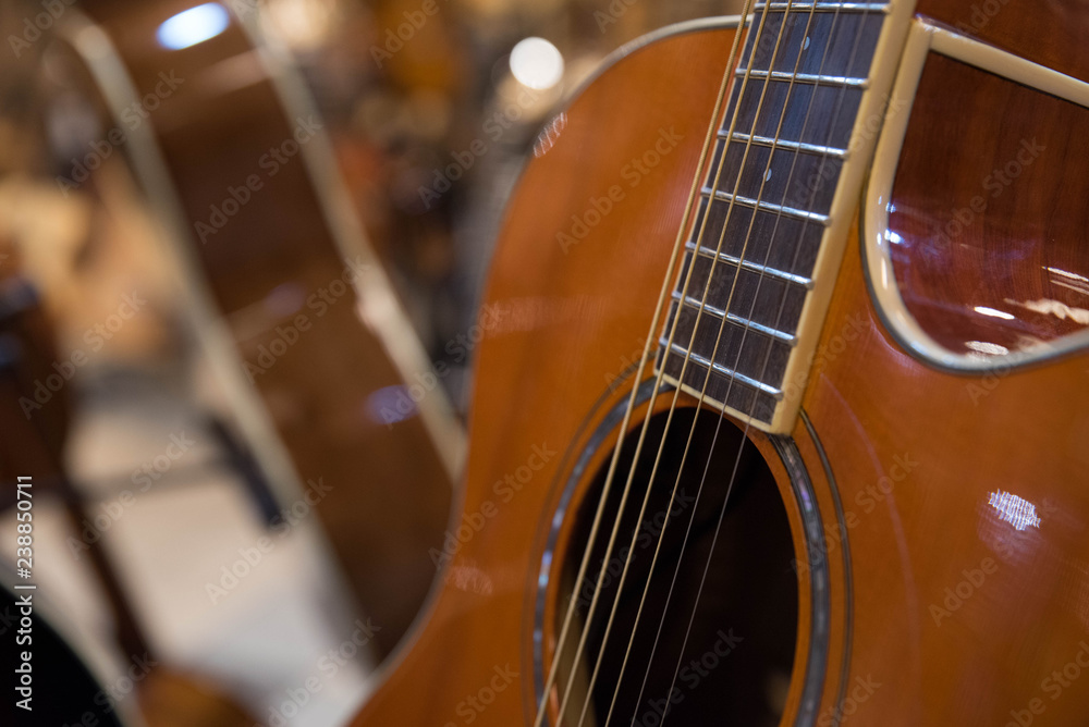 Closeup of row of different colorful guitars on the display for sale ...