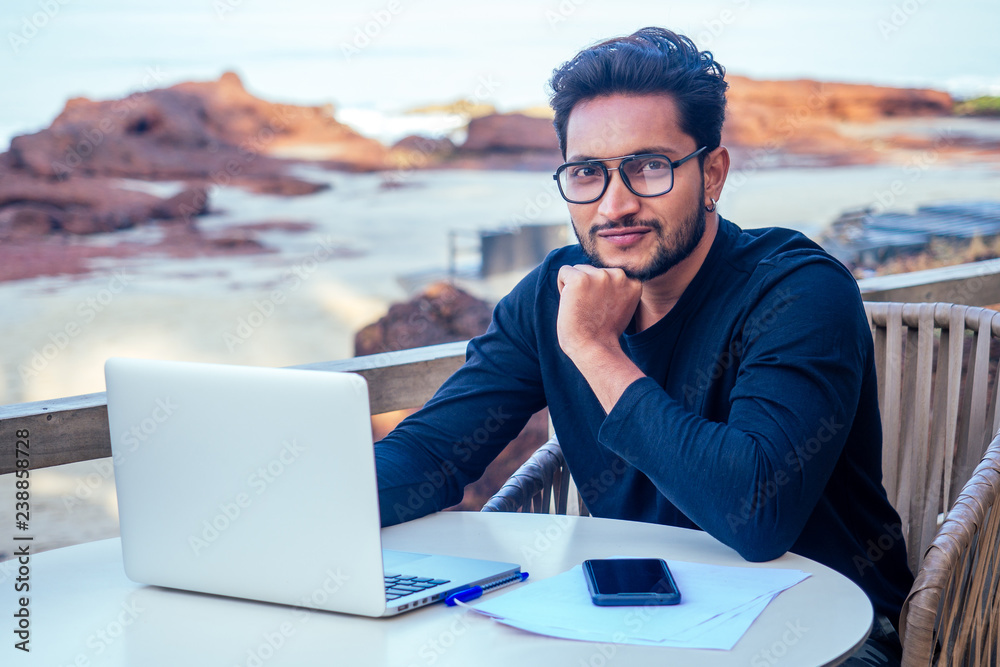 handsome and successful indian man in a stylish well-dressed freelancer ...