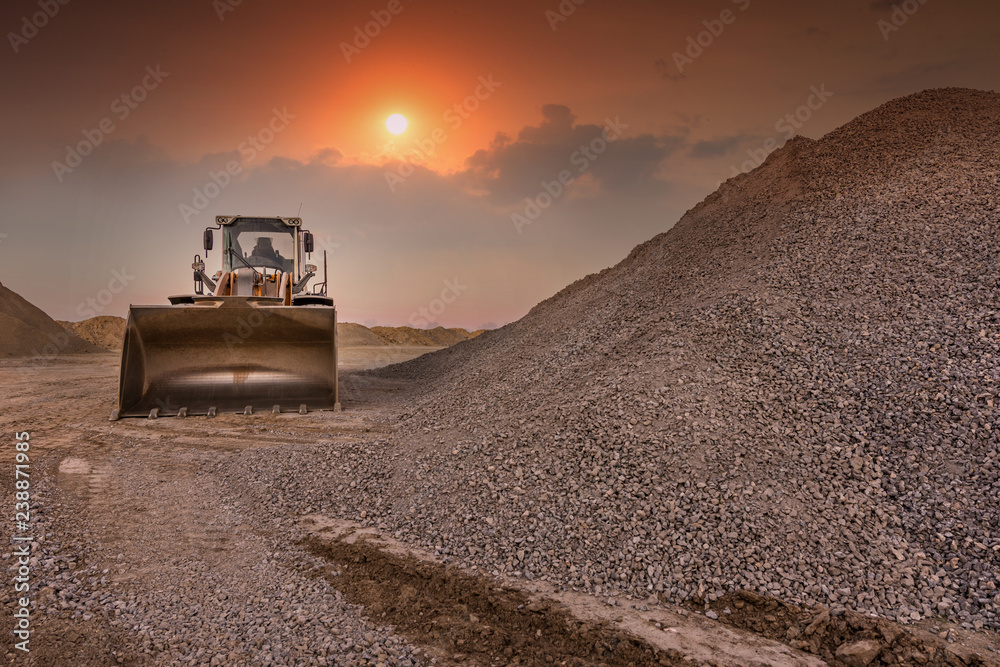 Excavator in a quarry of stone transformation in gravel for the ...