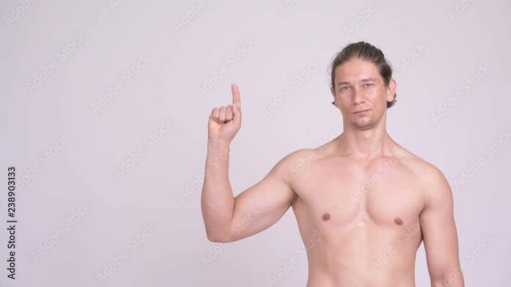 Handsome muscular shirtless man thinking while pointing up vídeo do ...