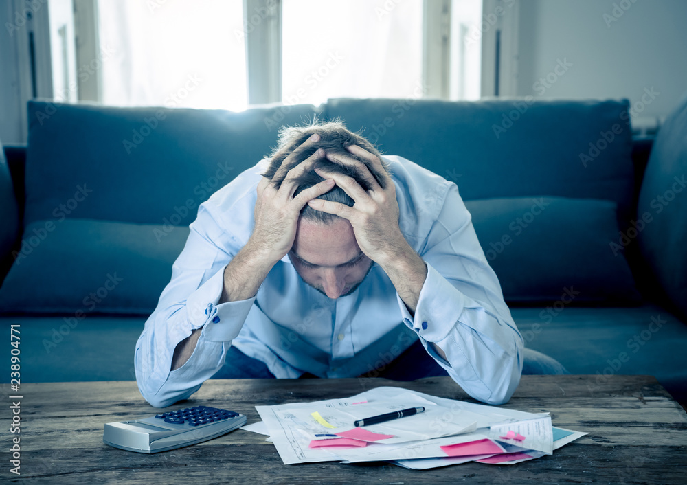 Upset man in stress paying bills counting finance with calculator bank ...