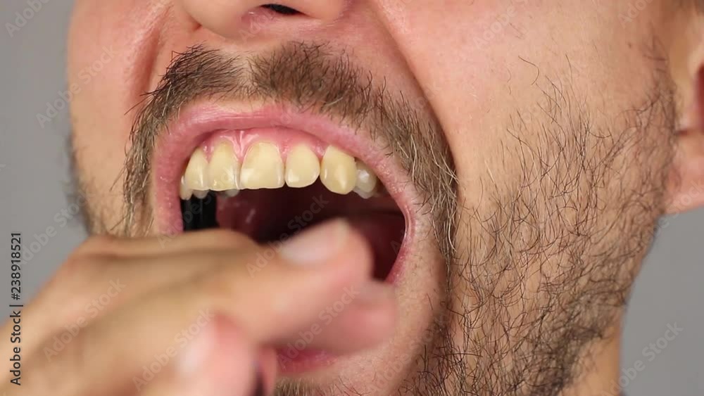 man with beard and mustache opens his mouth and thoroughly brushes his ...