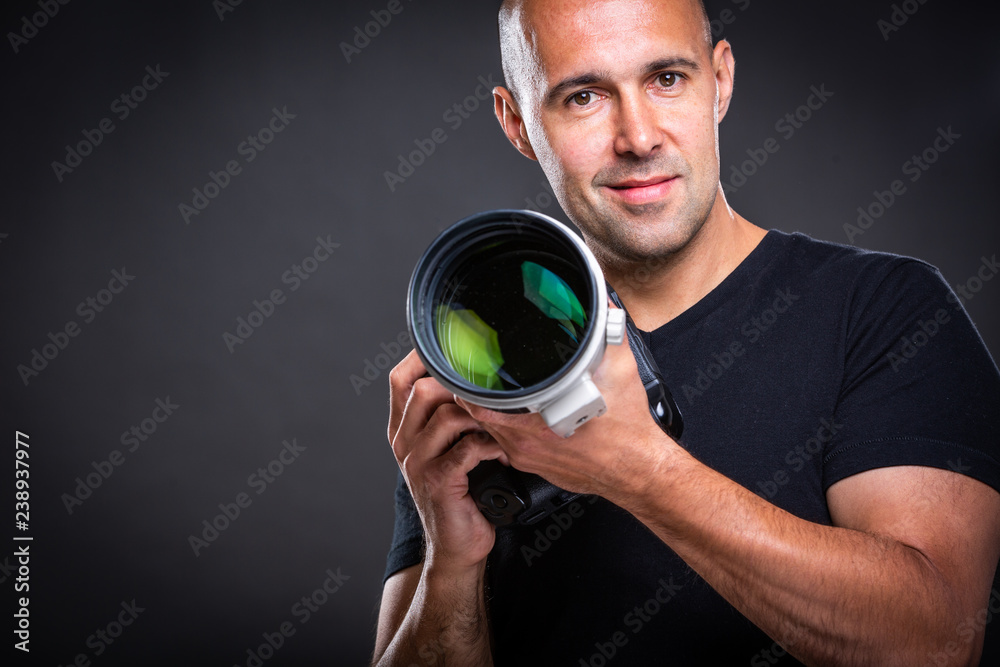 Young, pro male photographer in his studio during a photo shoot (color ...