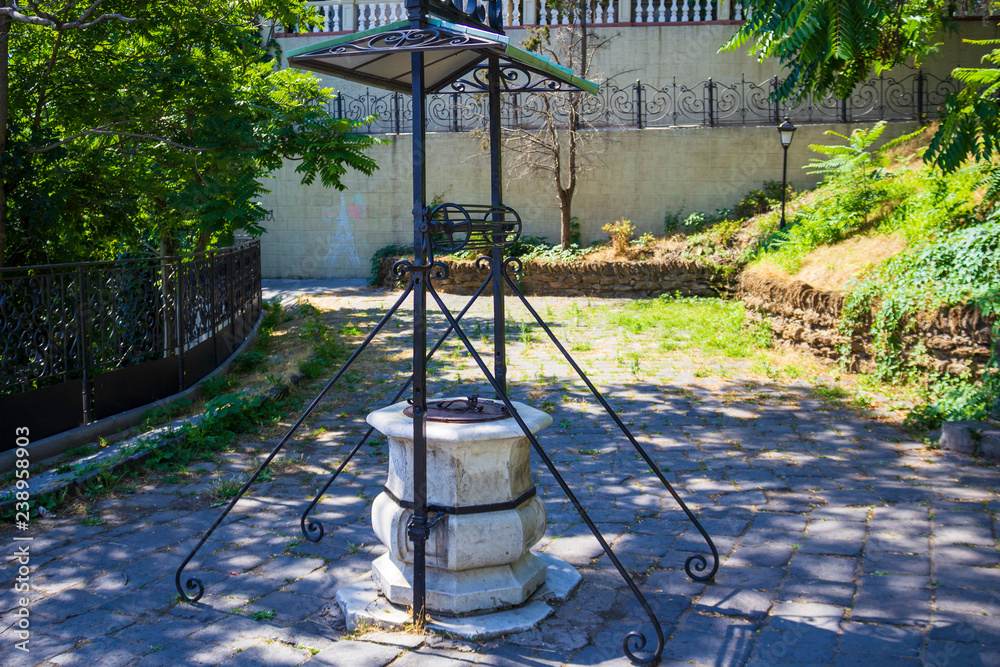 19th century well with a stone bowl and metal frame as a decorative ...
