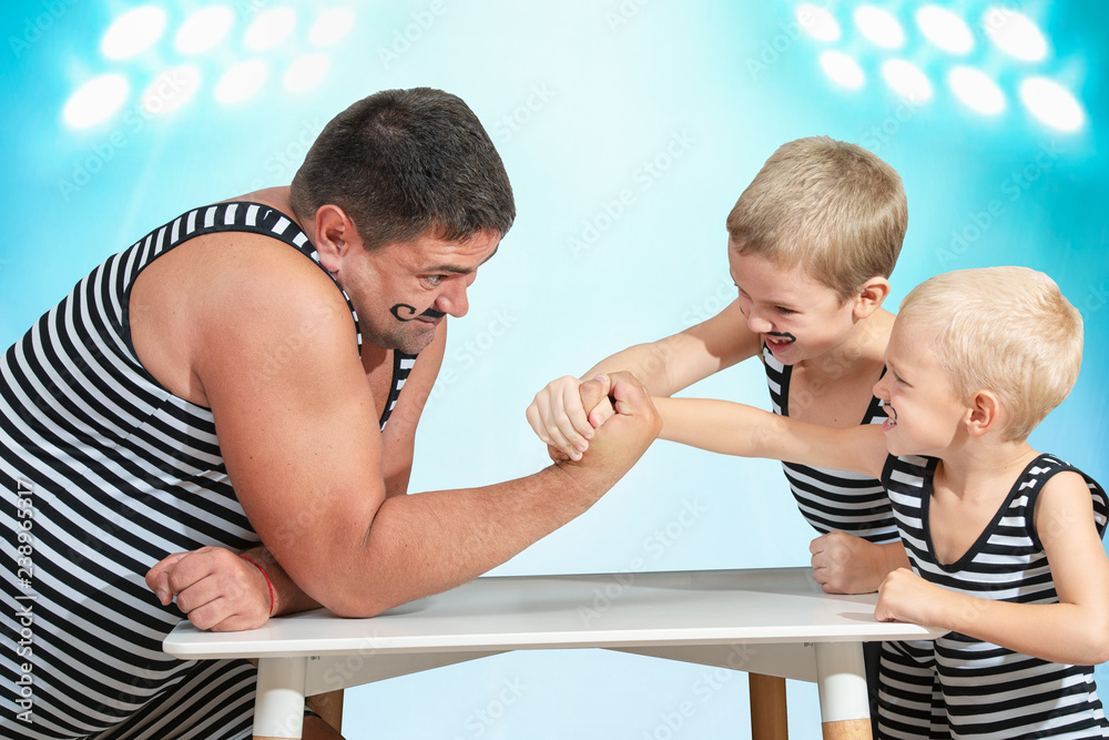 Family of strongman. The father of two sons in vintage costume of ...