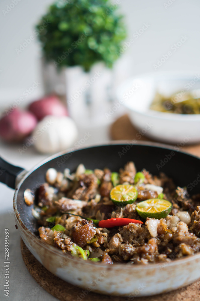 sizzling pork sisig with raw egg Stock Photo | Adobe Stock