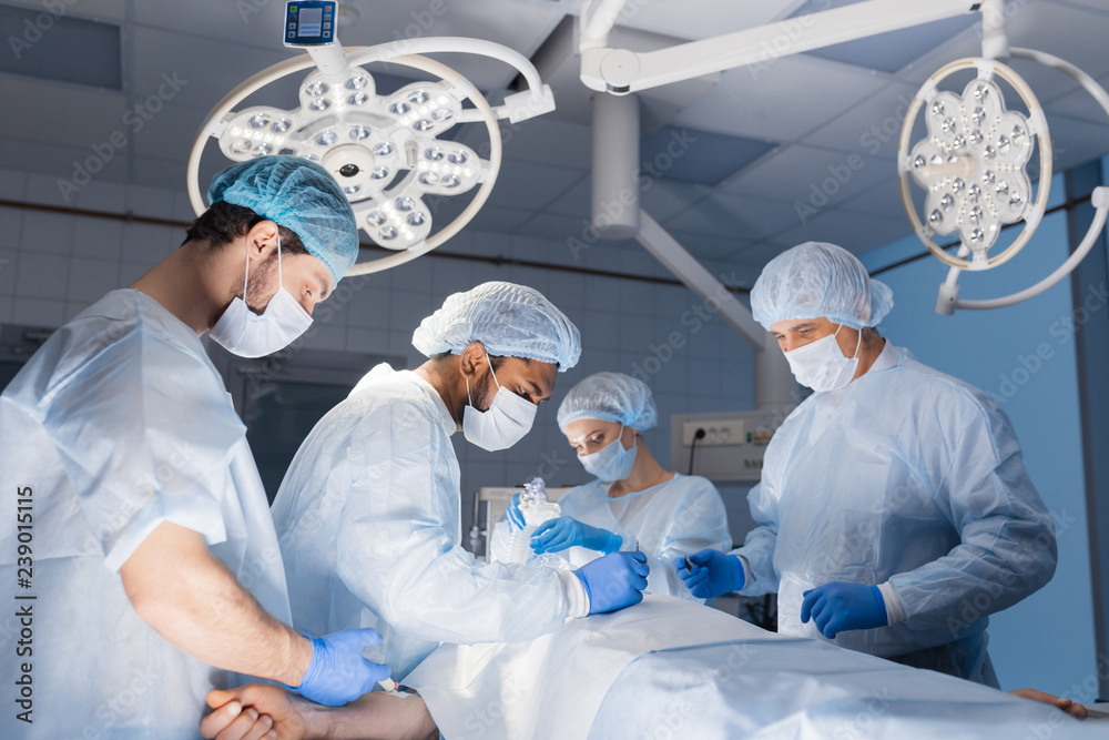 Complex surgery. Skilful surgeon works with scalpels and clamps during ...