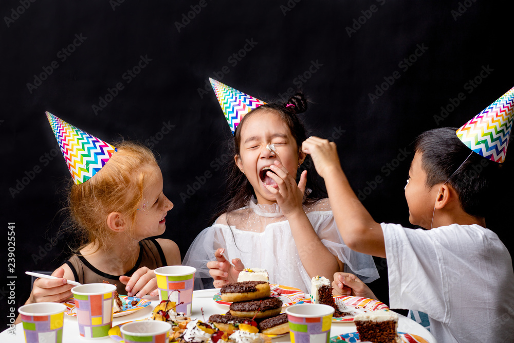 crazy kids are spreading the cake on the nose. closeup photo. studio ...