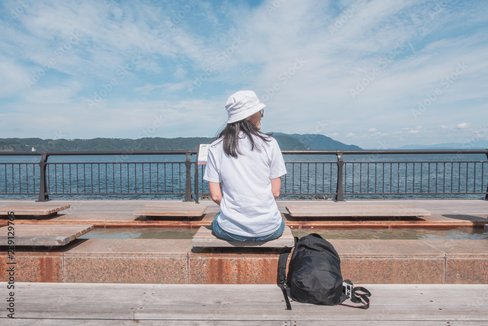 Foot onsen with Sakurajima mountain, sea and blue sky background ...