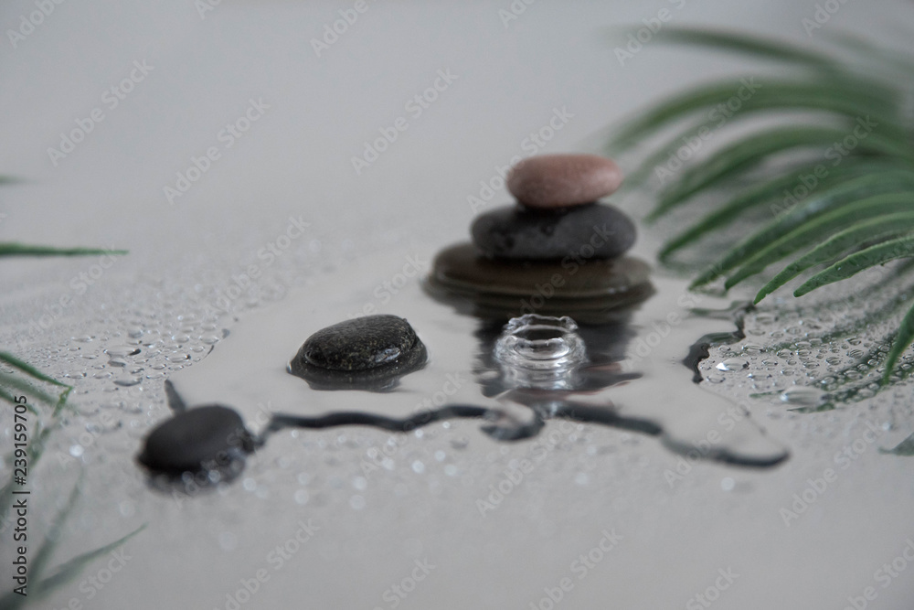 Pyramids of gray zen pebble meditation stones with green leaves on the ...