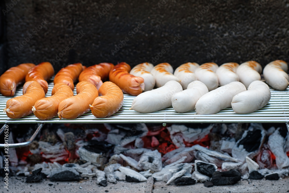 Foto de Rote Würste und Weißwürste auf Grill do Stock | Adobe Stock