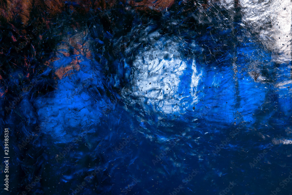 Clear transparent ice with small bubbles illuminated with white and ...