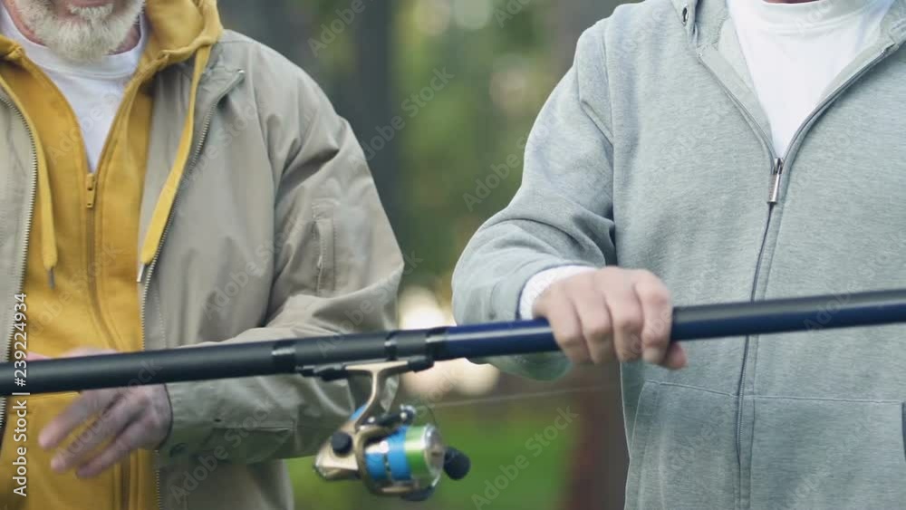 Gray-bearded man showing off his friend with new spinning, male hobby ...