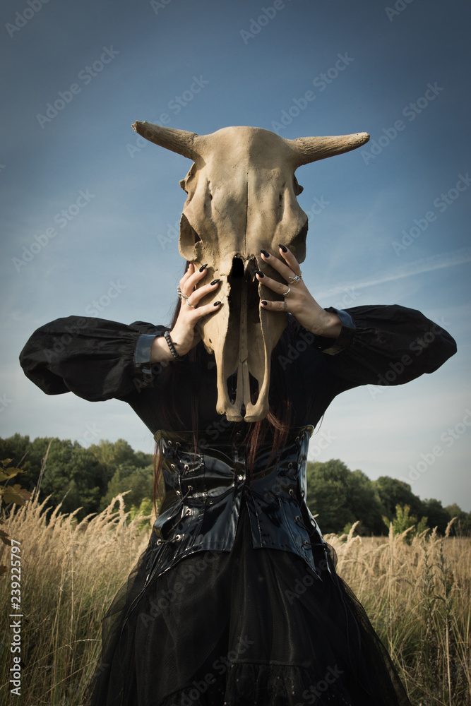 Gothic girl next to the skull of a cow Stock Photo | Adobe Stock