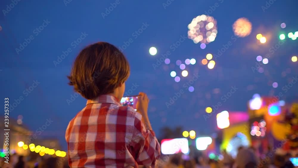 Little boy child filming pictures of beautiful fireworks in night sky ...