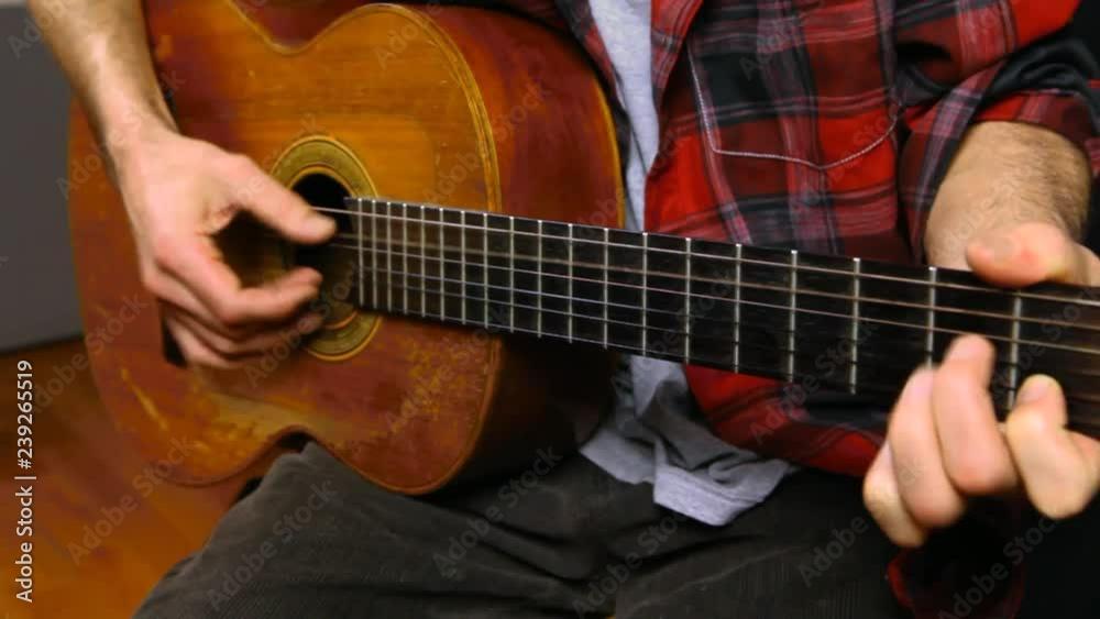 Man fingerpicking on classical guitar. Close up, fixed scene, focus on ...