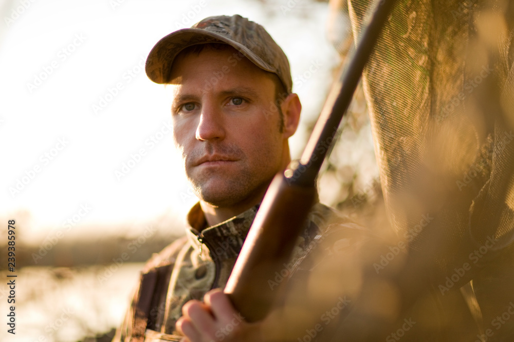 Mid-adult man holding a shotgun. Stock Photo | Adobe Stock