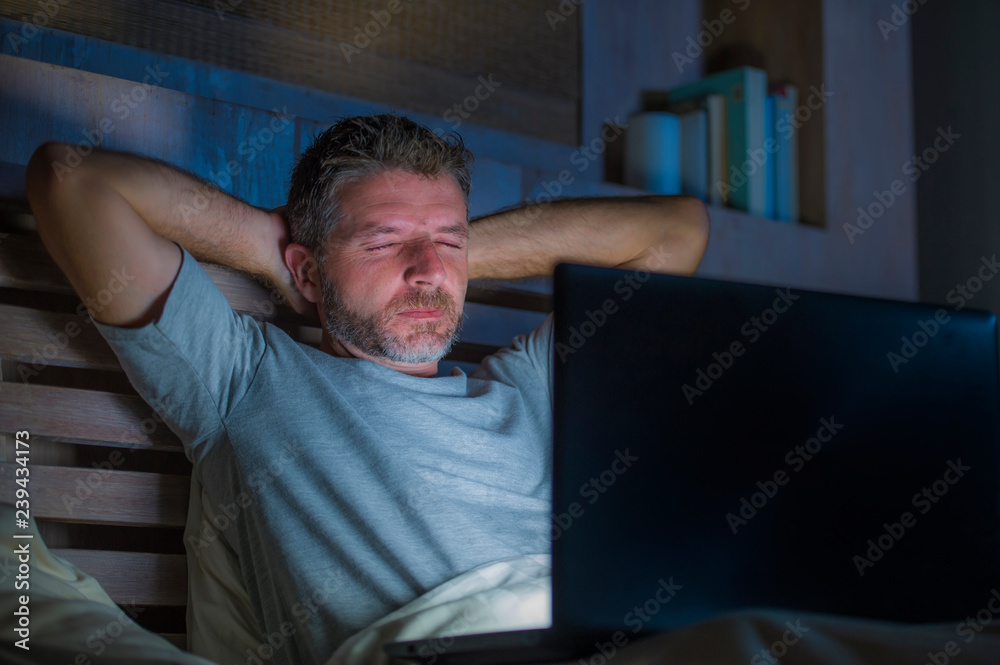 attractive tired and stressed workaholic man working late night ...