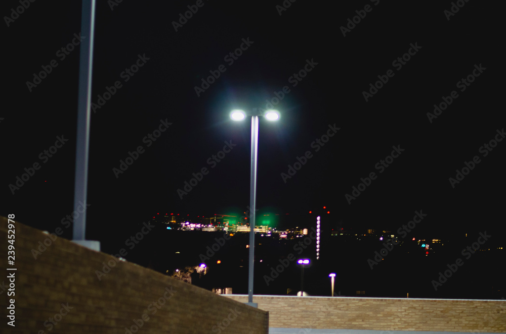 Under the city street lights on the parking garage above the city ...