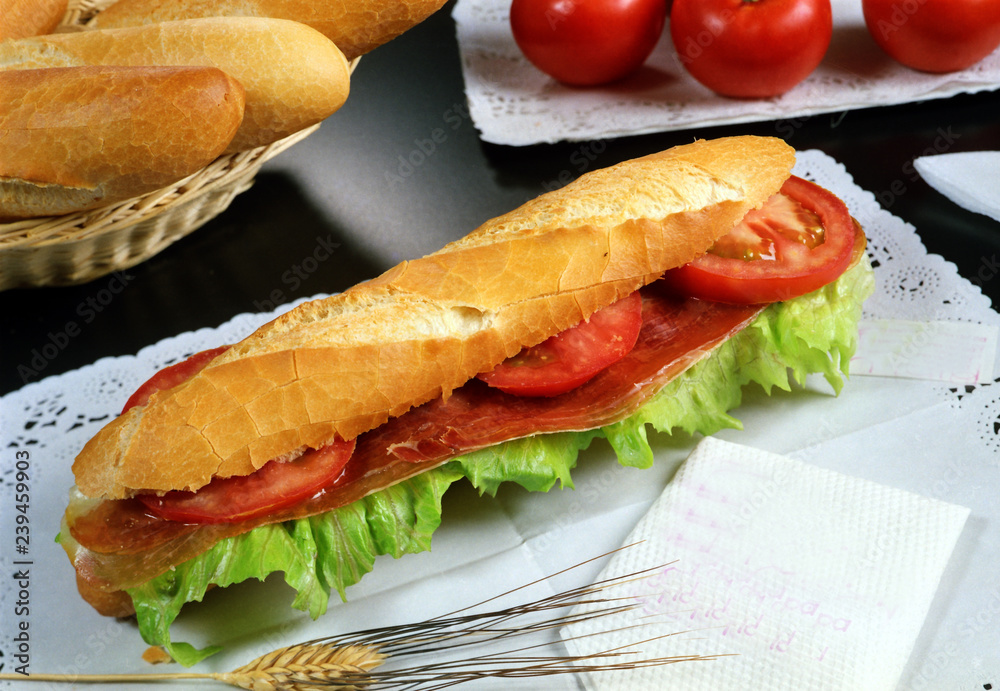 Bocadillo con pan de baguette, lechuga, tomate y jamón curado. Stock ...
