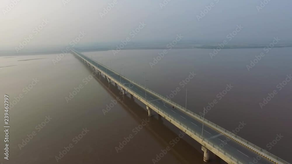 Panning aerial view of a motorcycle driving on the newly constructed ...