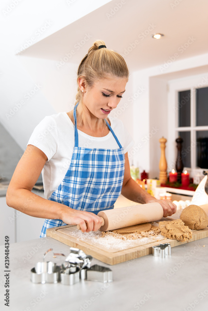 junge blonde Frau backt in der Küche Pläzchen Keckse für Weihnachten ...