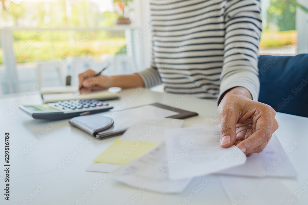 Woman with bills and calculator. Woman using calculator to calculate ...