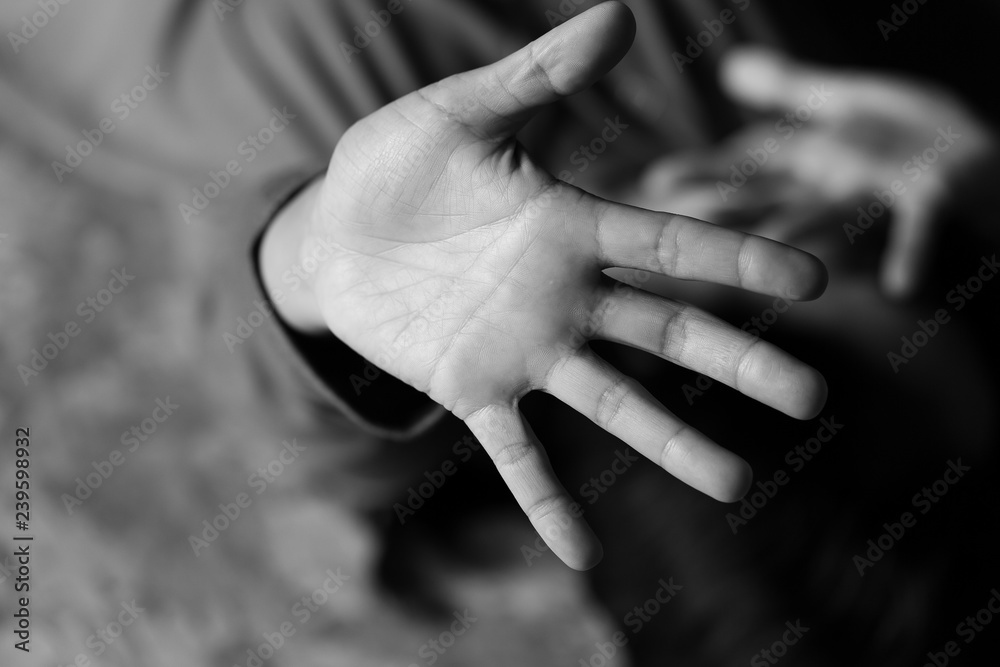 The palm of a female hand giving the signal to stop. The dark, moody ...