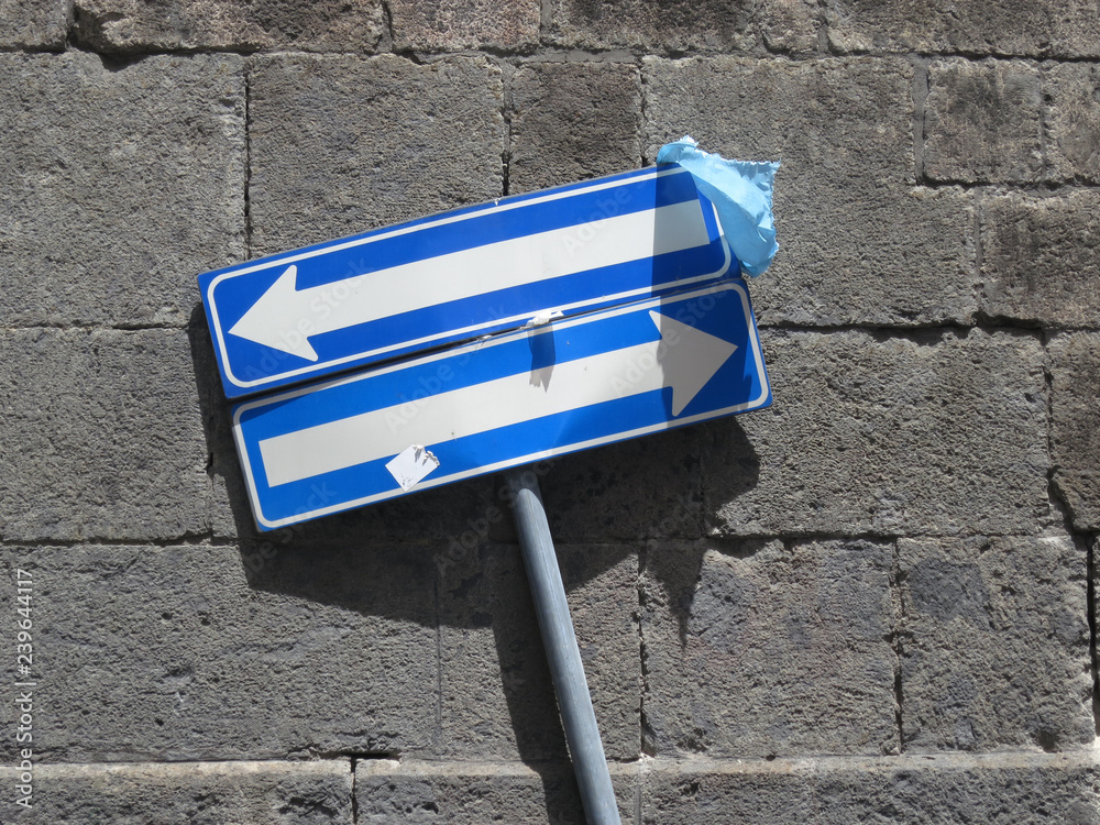 traffic signs, an arrow pointing to hte left and an arrow pointing to ...