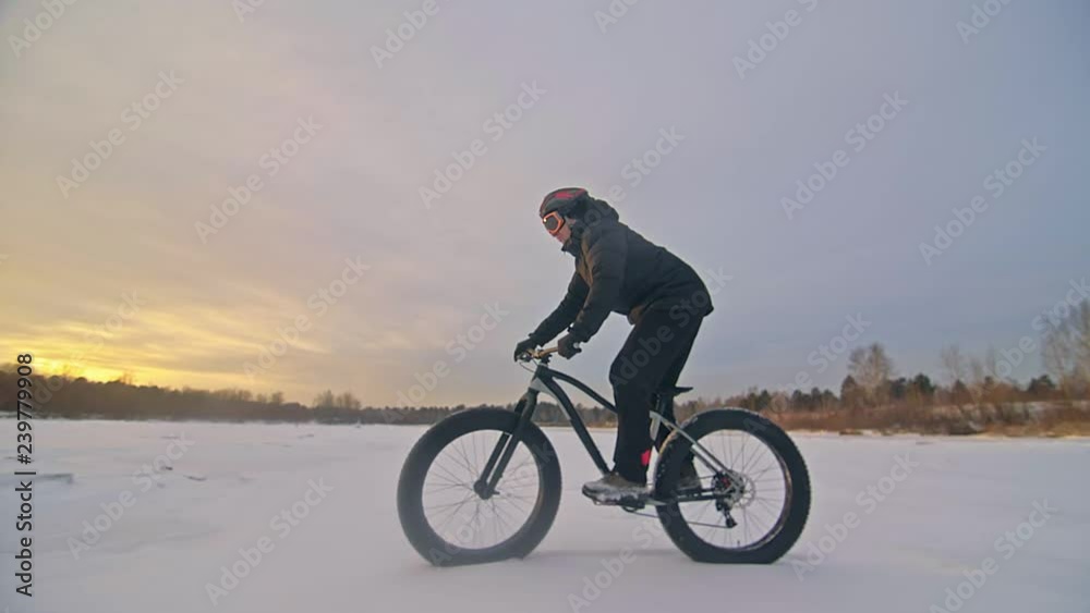 Professional extreme sportsman biker riding fat bike in outdoors ...
