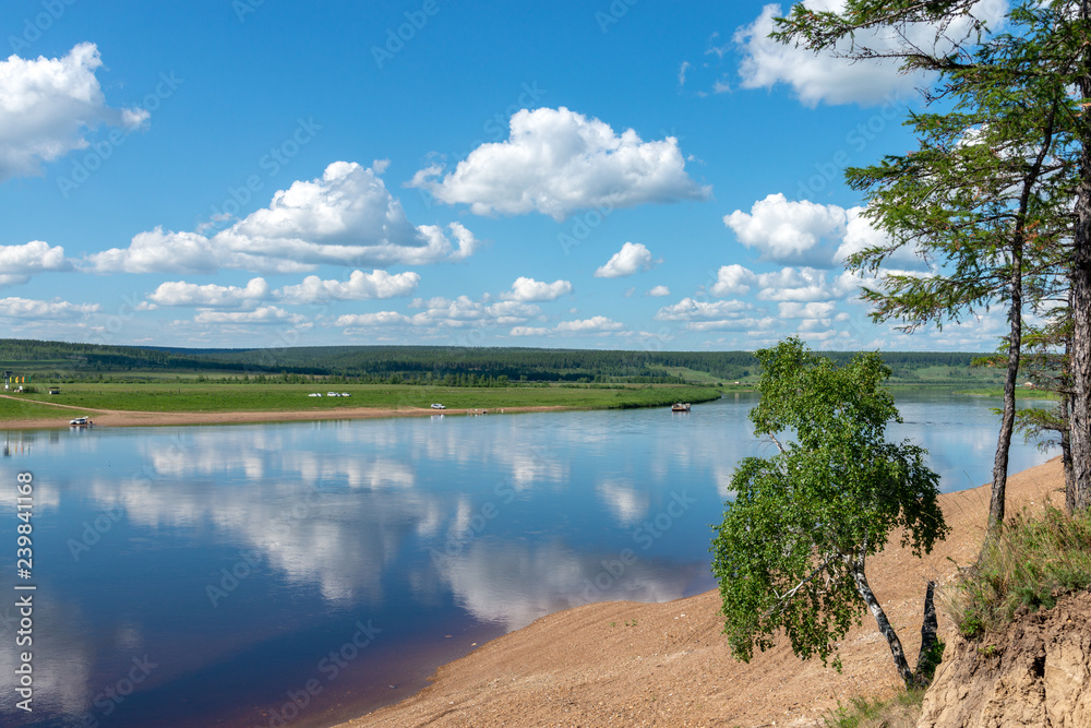 typical rural landscape with river, cloudy sky and reflection in ...