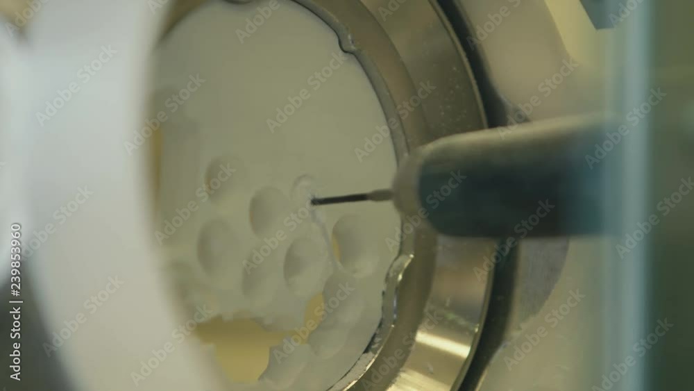 Dental milling cnc machine carving out shape of human teeth close-up ...